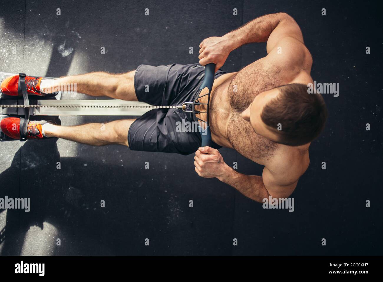 sporty male workouts on power exercise machine in a gym club Stock ...