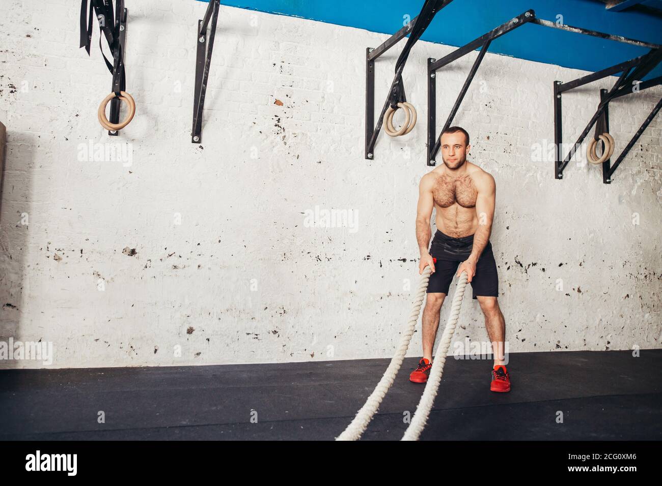 Men with battle rope battle ropes exercise in the fitness gym Stock ...
