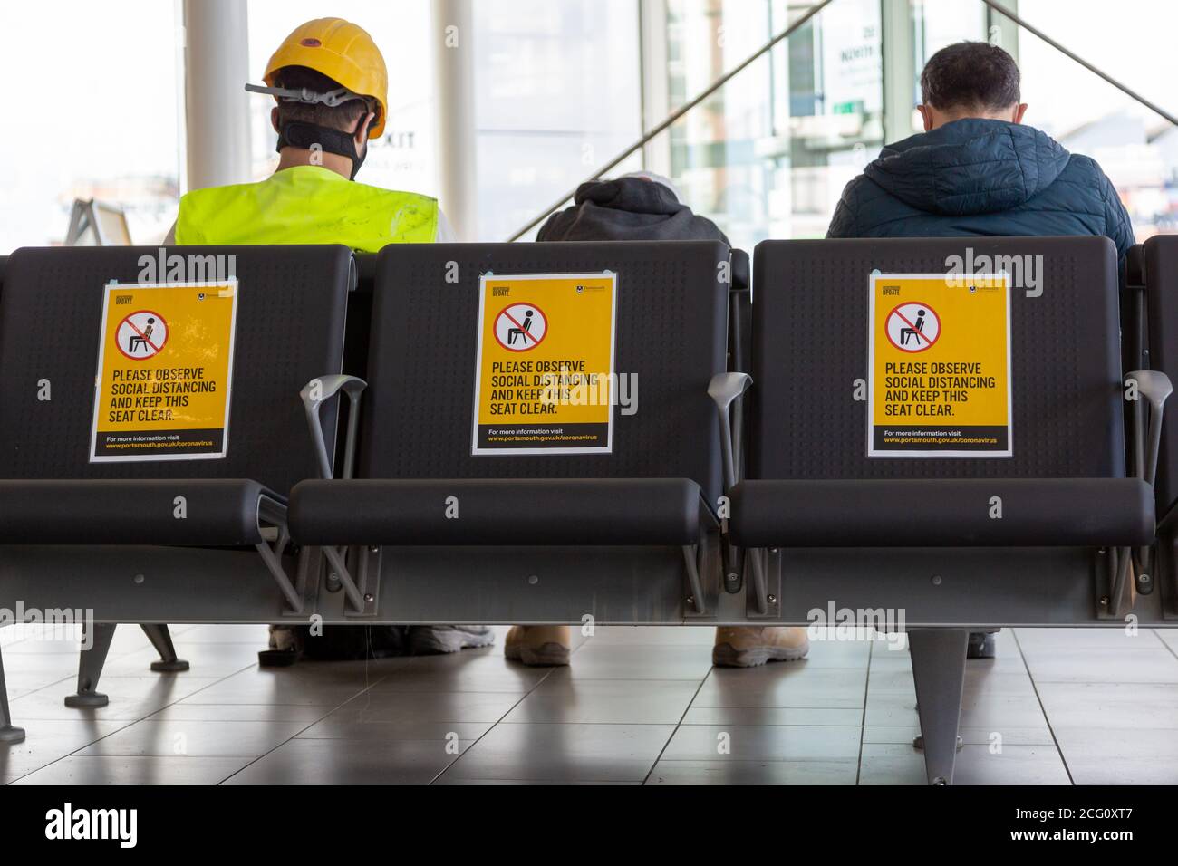 people sitting on the opposite side of benches with signs asking you ...