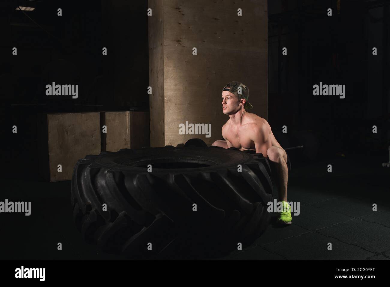 crossfit training - man flipping tire in gym Stock Photo - Alamy