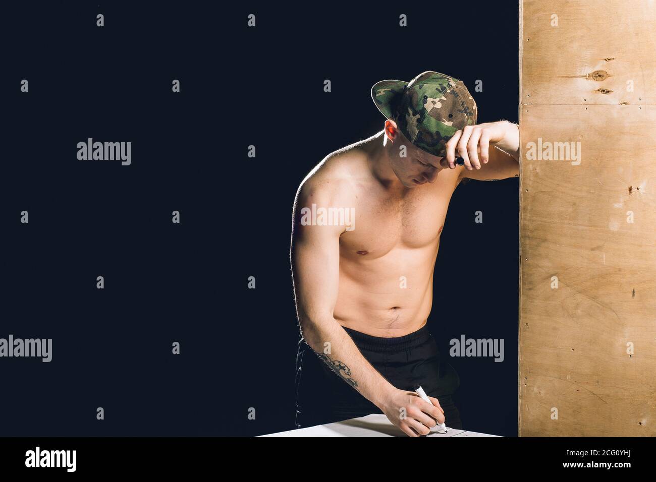 Fitness sporty man writing on blank notepad while sitting on urban ...