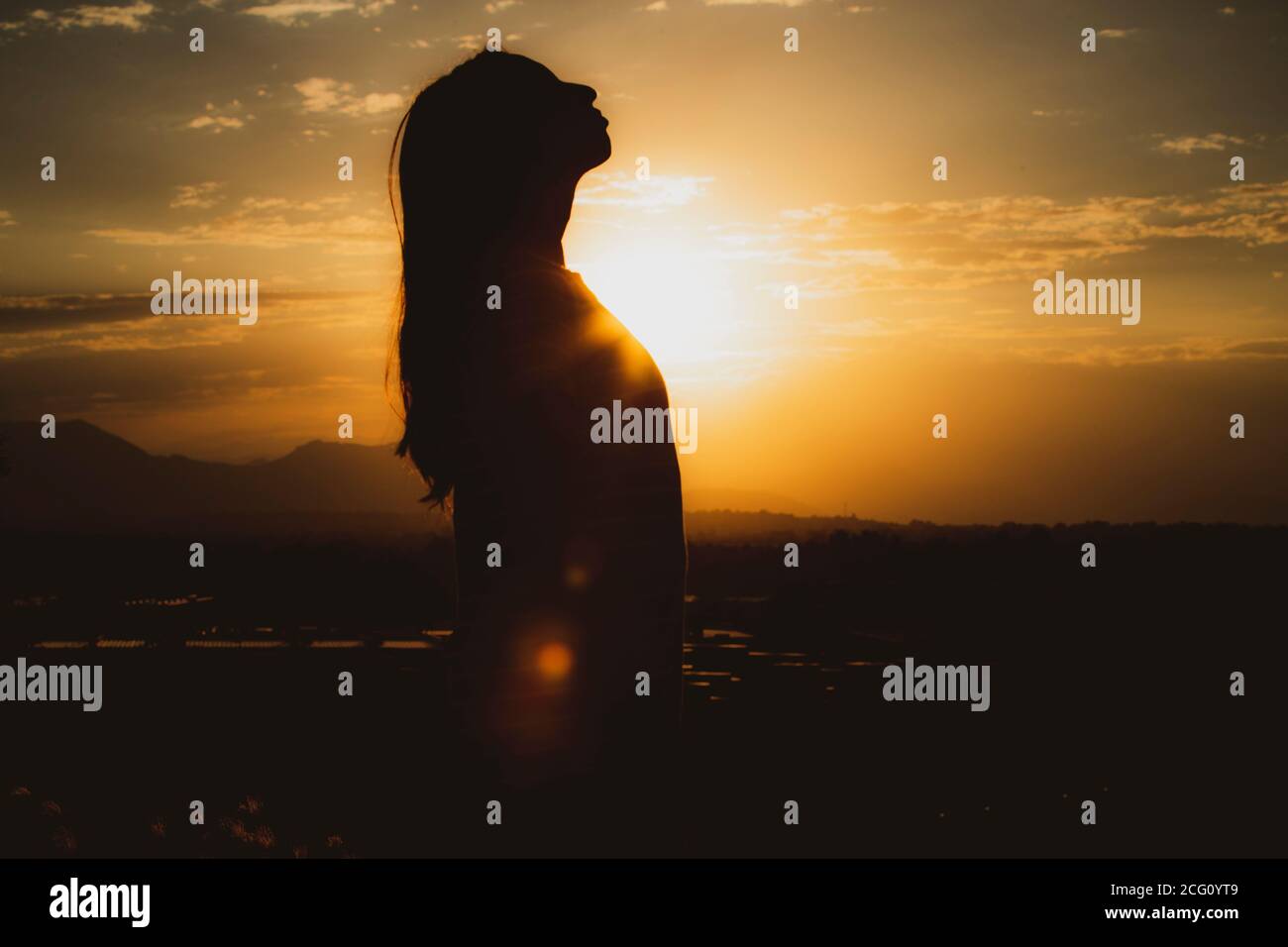 Side profile of woman at golden hour Stock Photo - Alamy