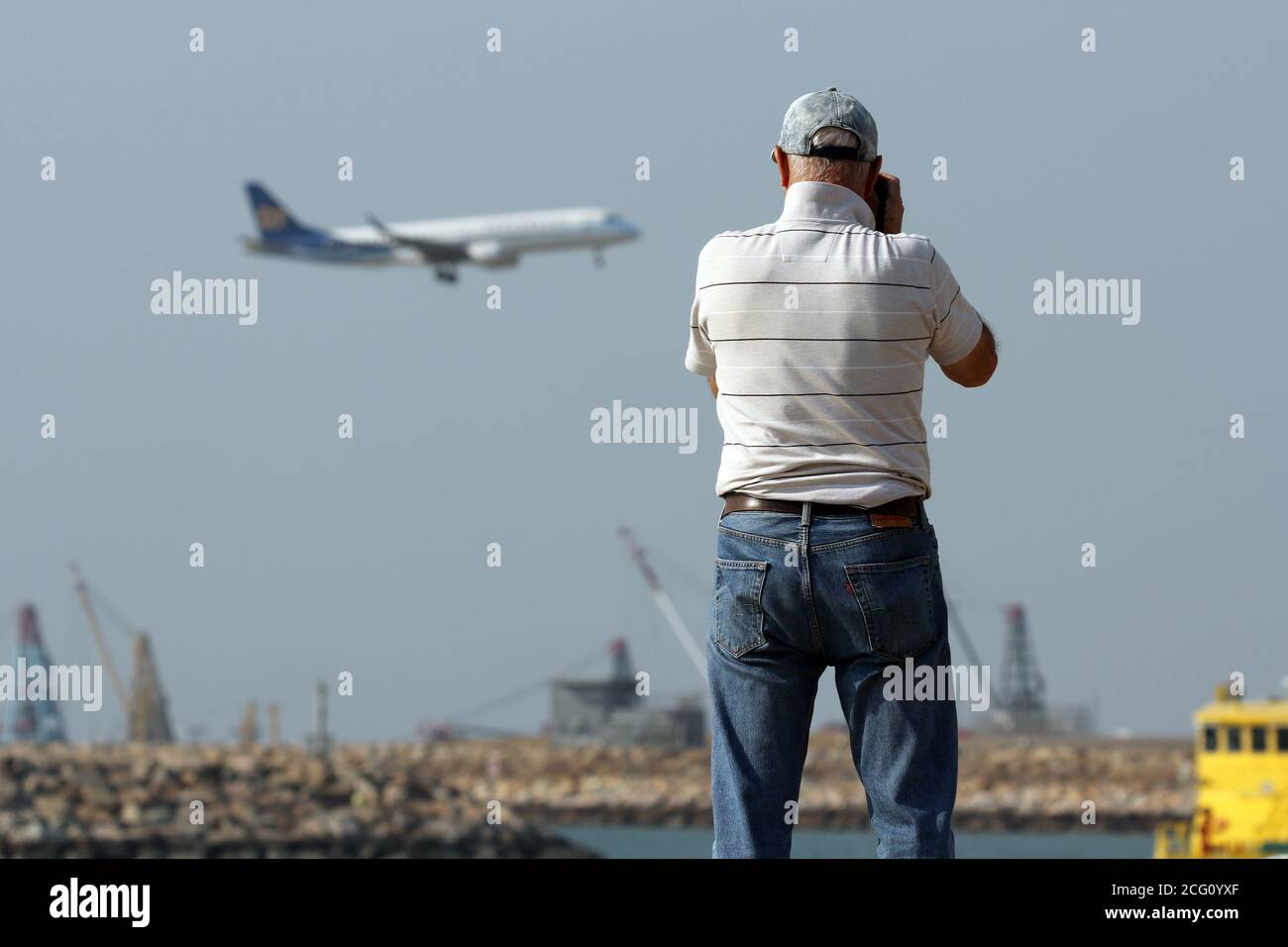 A man photographing an aircraft landing at Hong Kong airport Stock ...