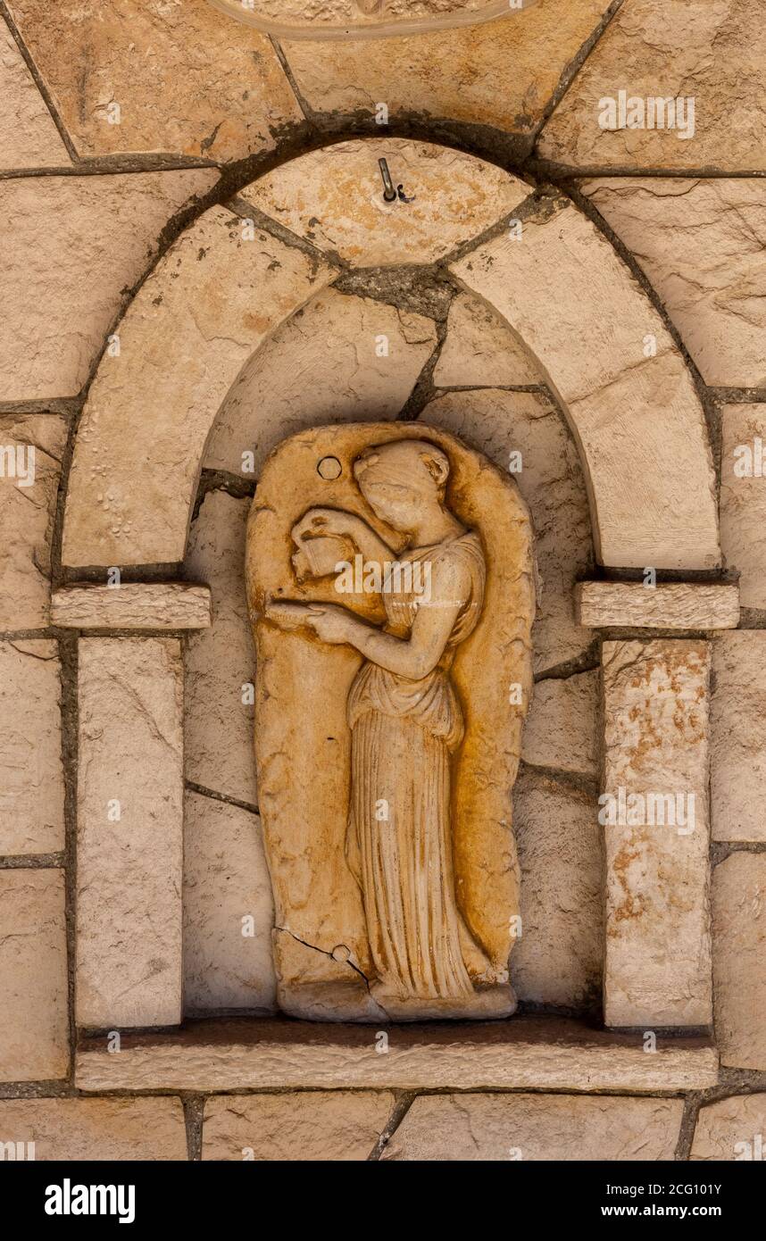 a classical greek stone plaque or sculpture inset into a wall on the ...