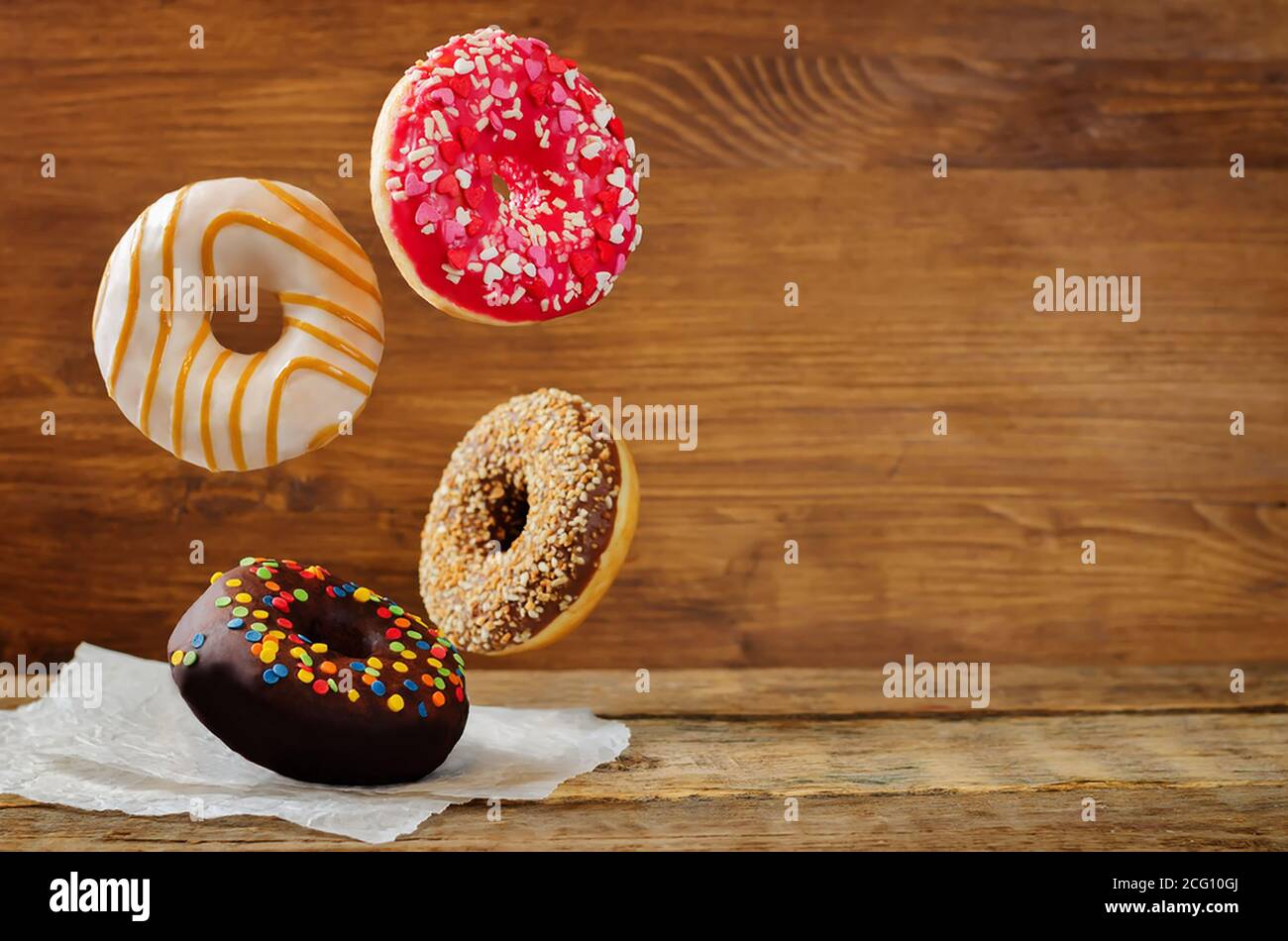 Flying donuts on a wood background. toning. selective focus Stock Photo ...