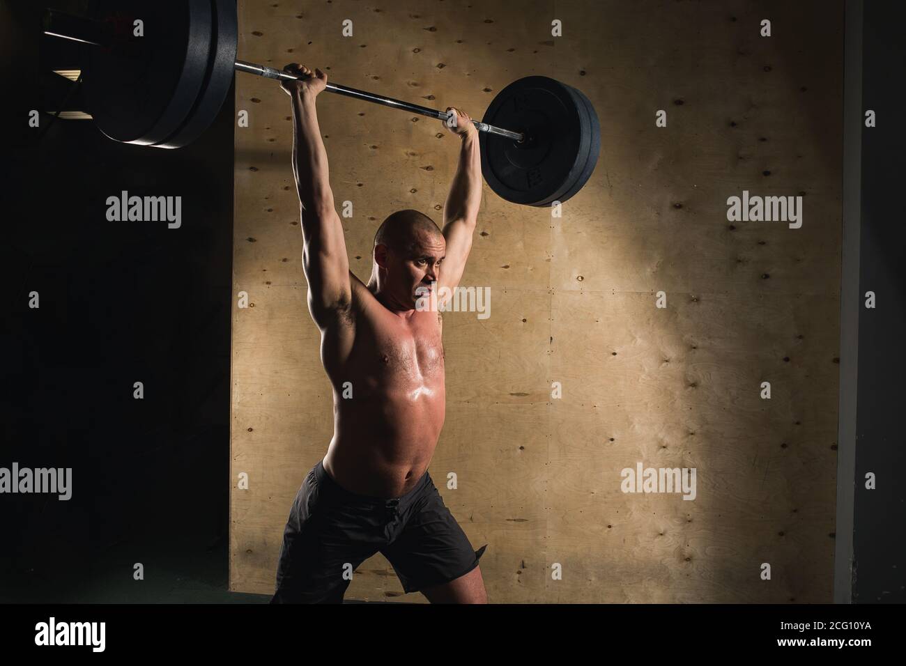 Muscular man at a crossfit gym lifting a barbell Stock Photo - Alamy