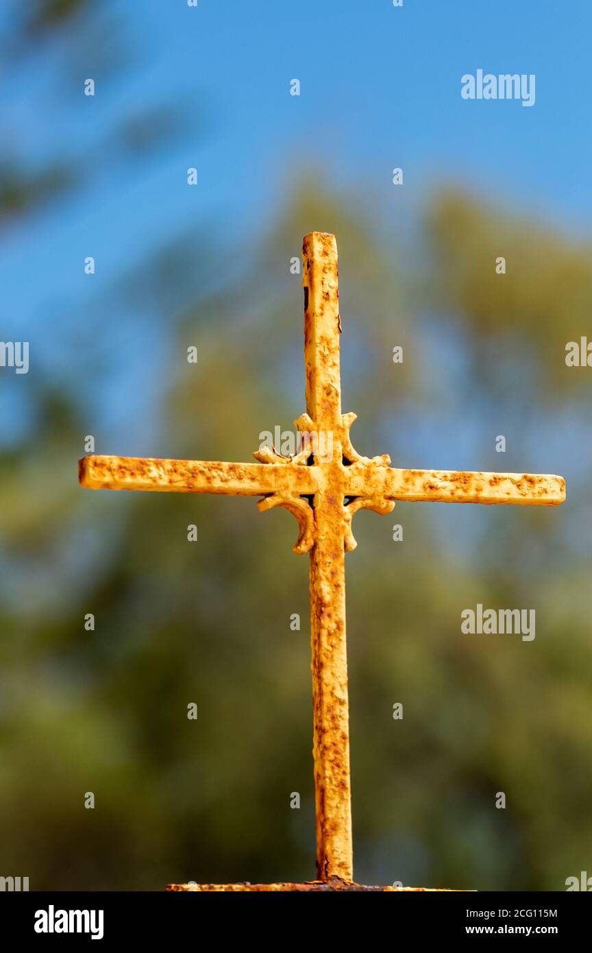 a ruty or corroded painted metal holy symbol, emblem or cross on a ...