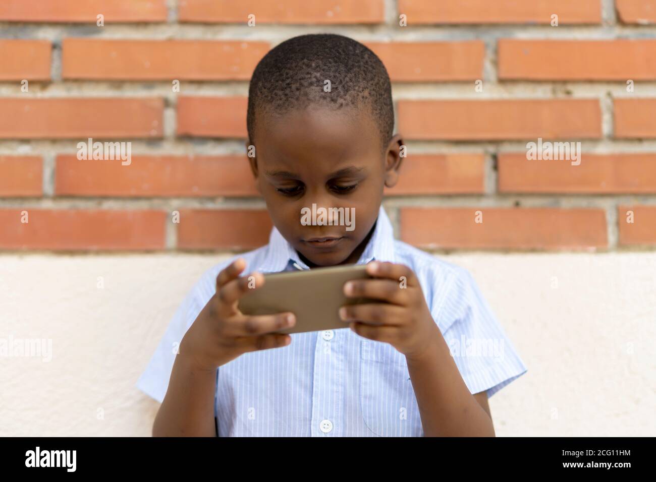 African boy playing with his smartphone Stock Photo - Alamy