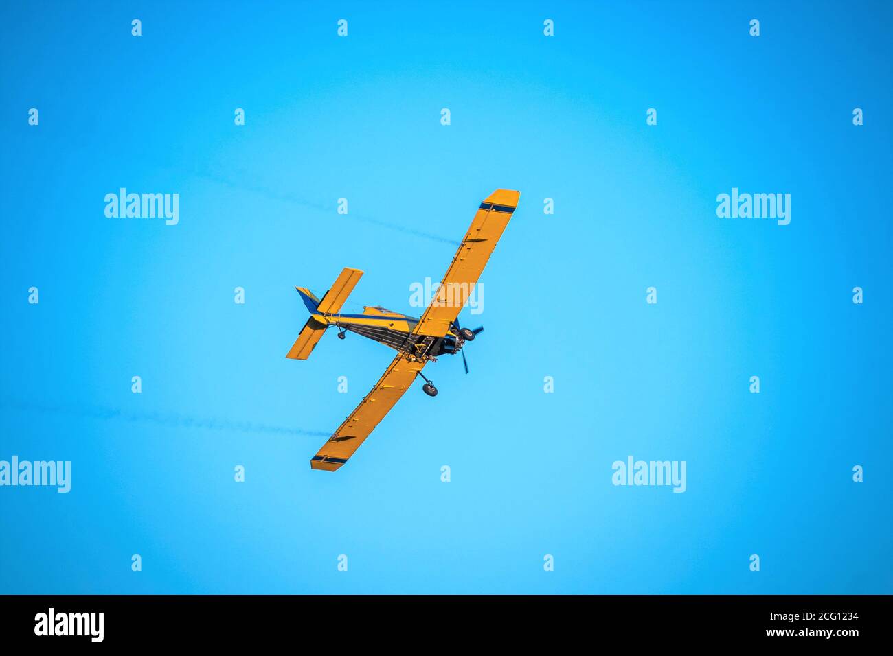 Orange airplane flies in the blue and clear sky Stock Photo - Alamy