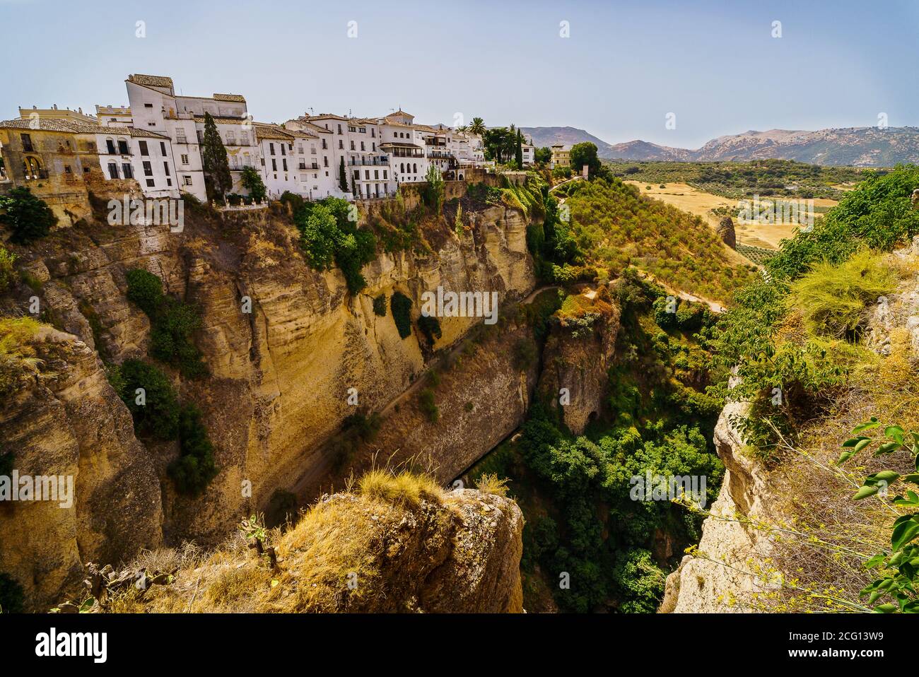 white village on cliffs with bushes, trees and mountains in the ...