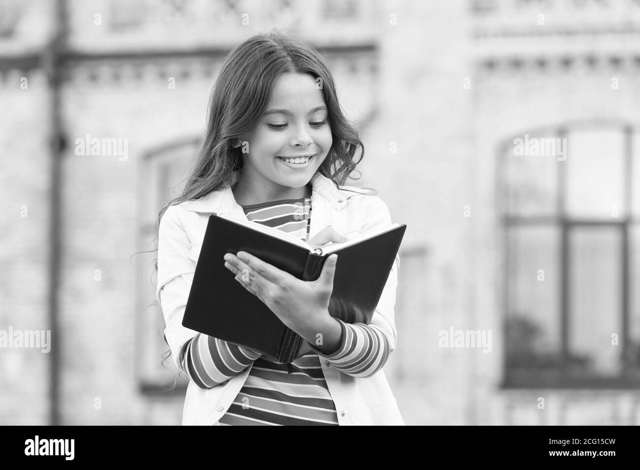 Access to much more than just book. Knowledge concept. Little girl hold ...