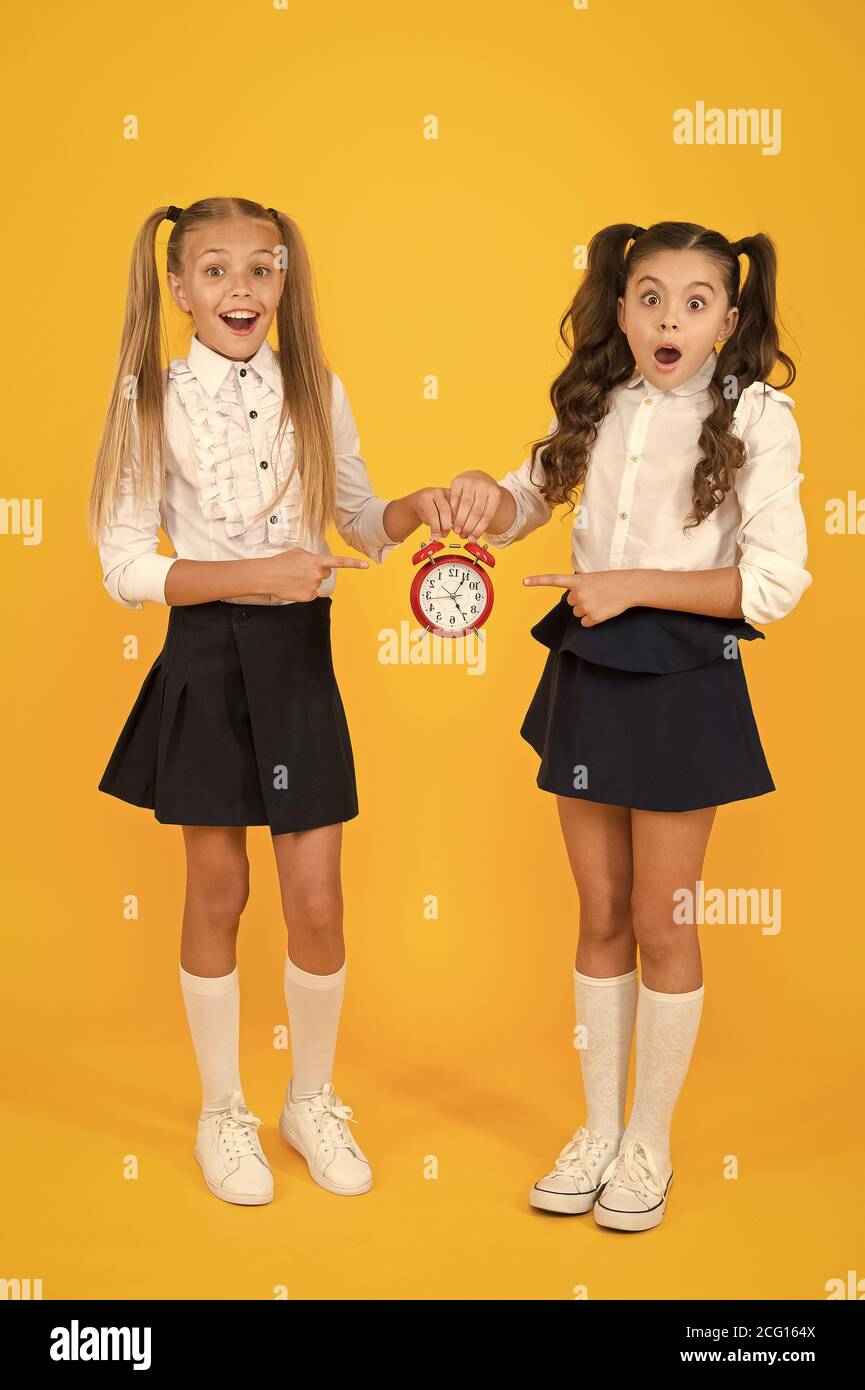 It is time. School schedule. Schoolgirls and alarm clock. Children ...