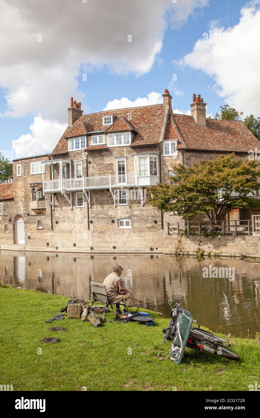 People sitting enjoying the summer sunshine and a man fishing on the ...