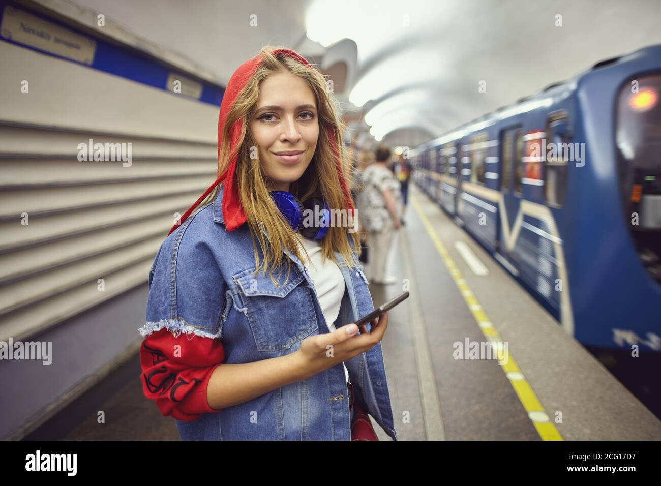 Smiling woman is standing in the underground. Beautiful young girl in ...