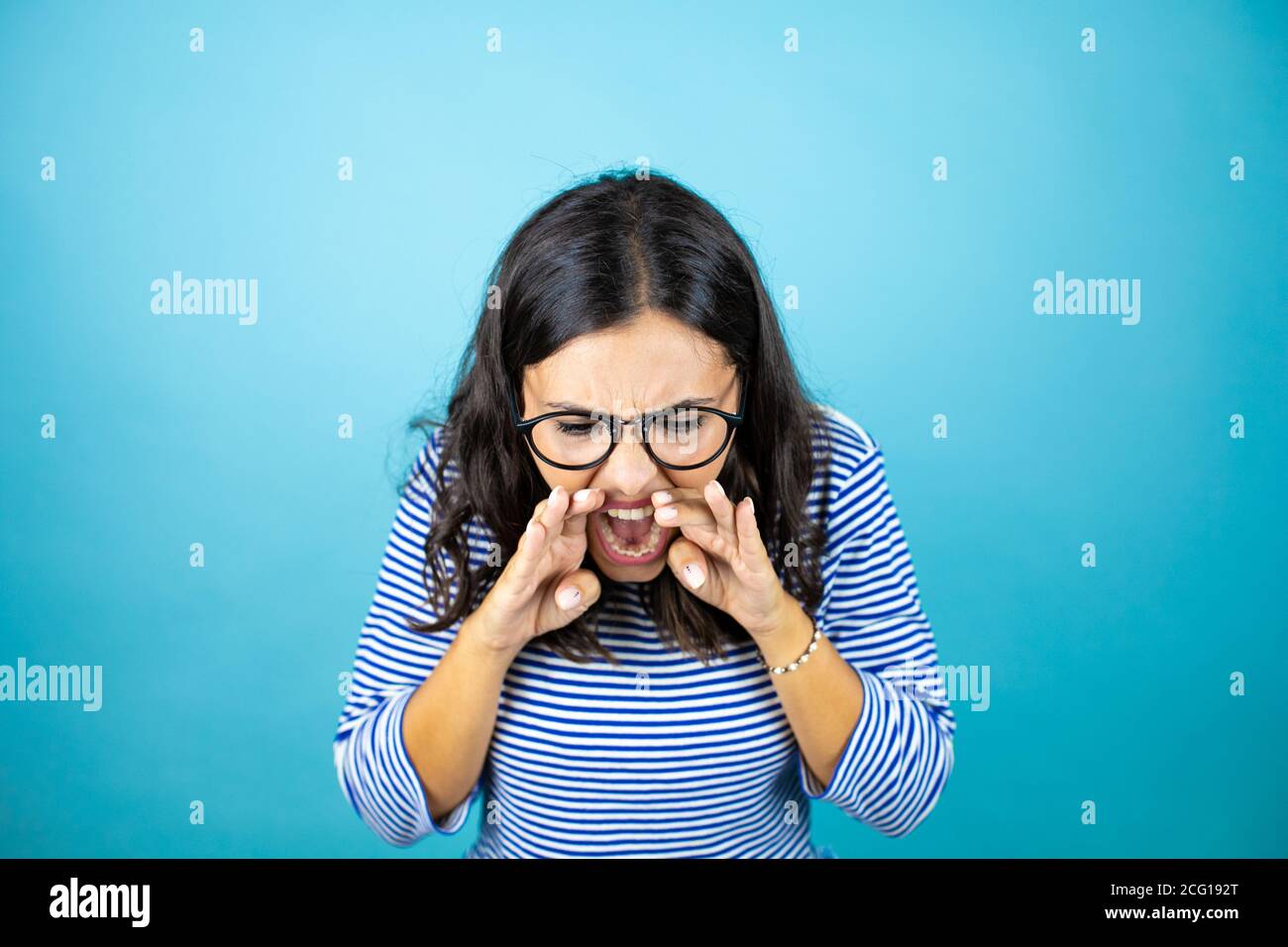 Pretty woman wearing glasses standing over insolated blue background ...