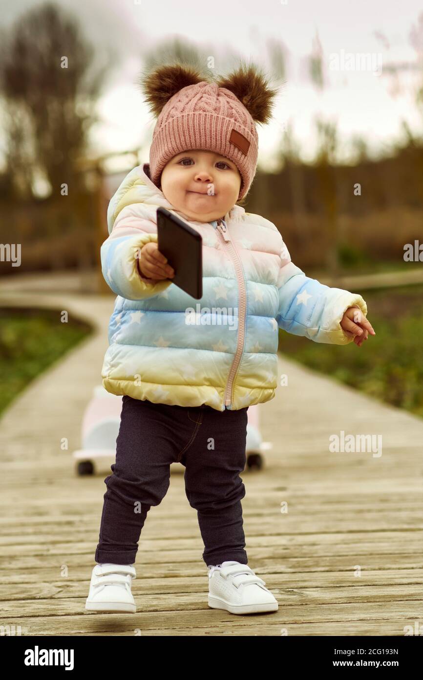 A 12 month old baby driving a toy motorcycle down a road Stock Photo ...