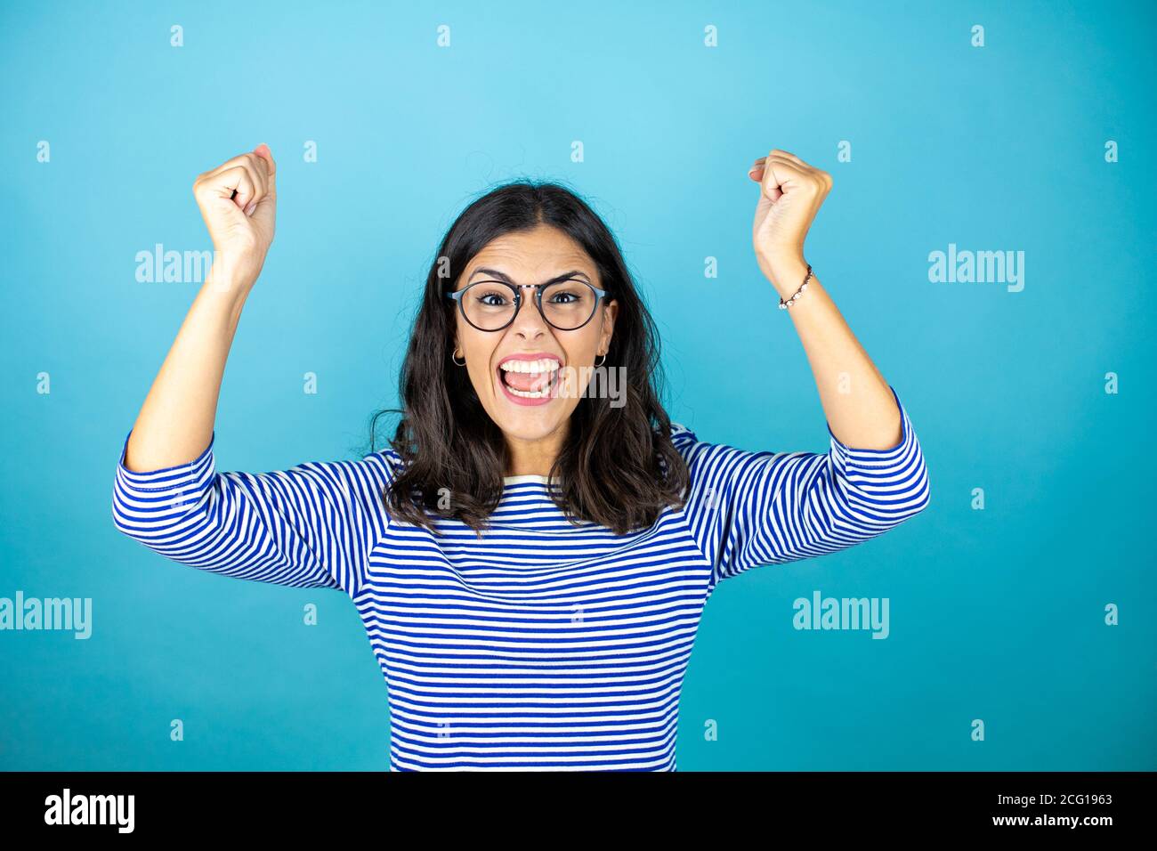Pretty woman wearing glasses standing over insolated blue background ...