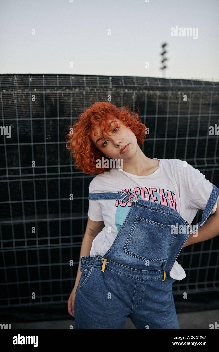 Young alternative redhead girl posing in a black fence Stock Photo - Alamy