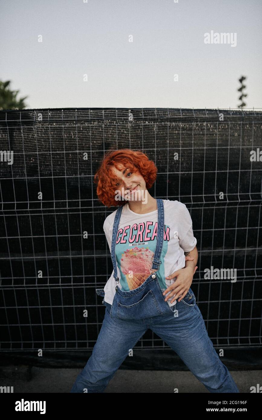 Young alternative redhead girl posing in a black fence Stock Photo - Alamy