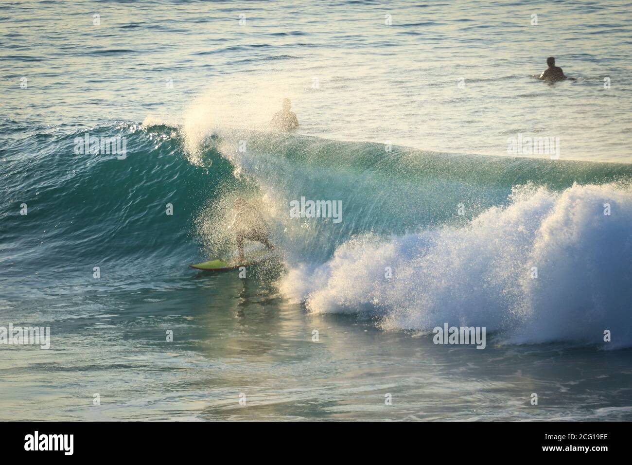 Surfer on Ocean Wave Getting Barreled at Sunset Stock Photo - Alamy