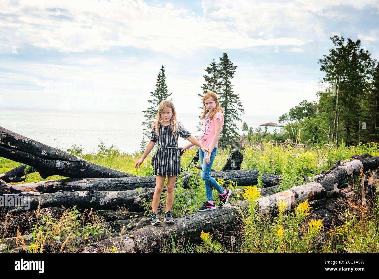 Two Young Girls Walking on Log Stock Photo - Alamy