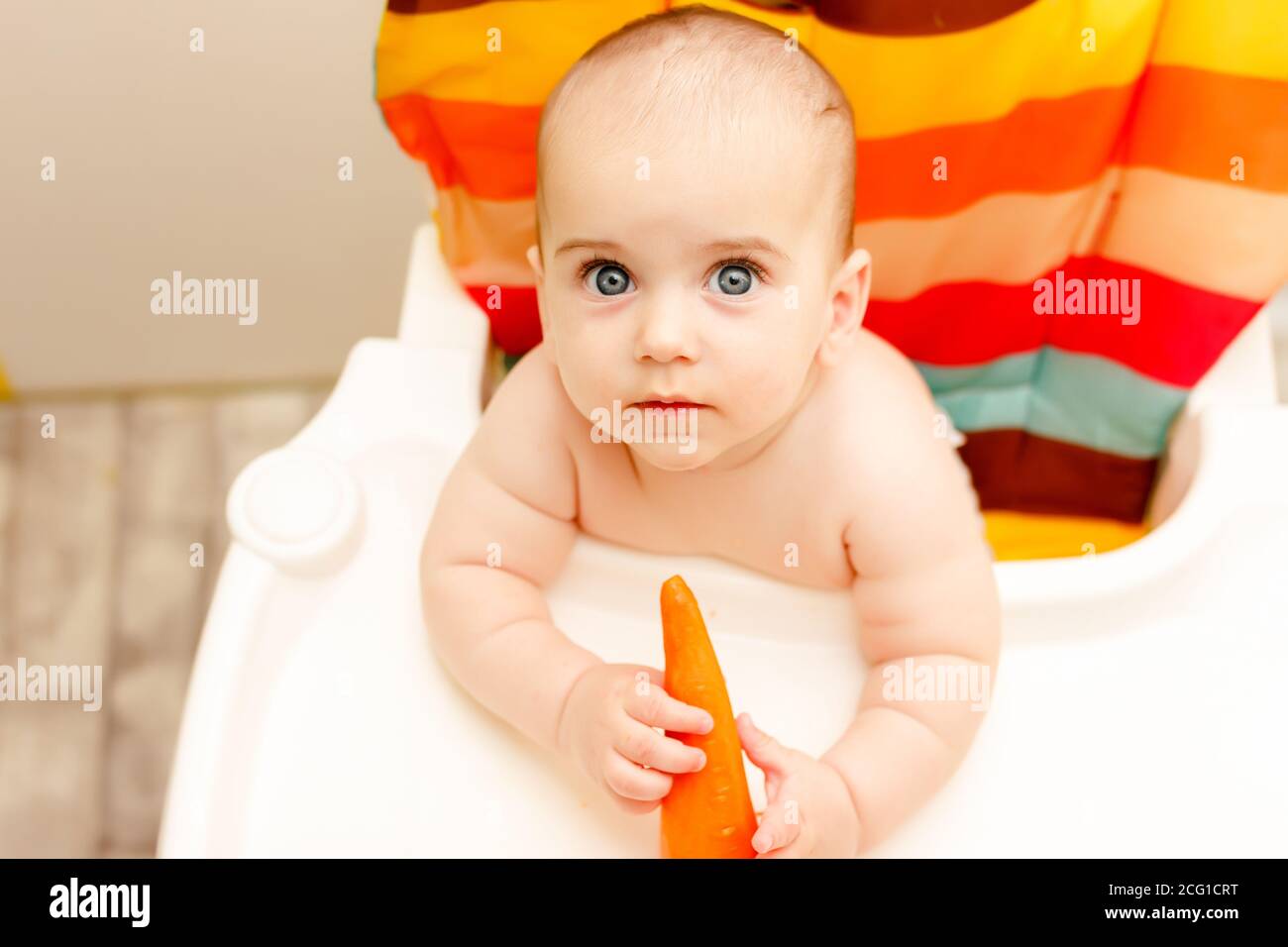 Happy Little Baby Eating a Carrot Stock Photo - Alamy