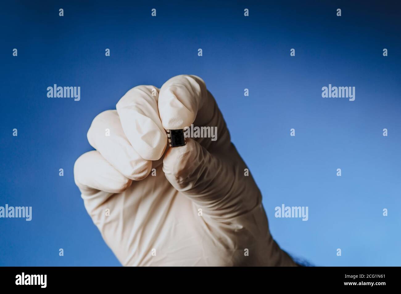 Hand in a white glove holds a chip. Chipization of people after an ...