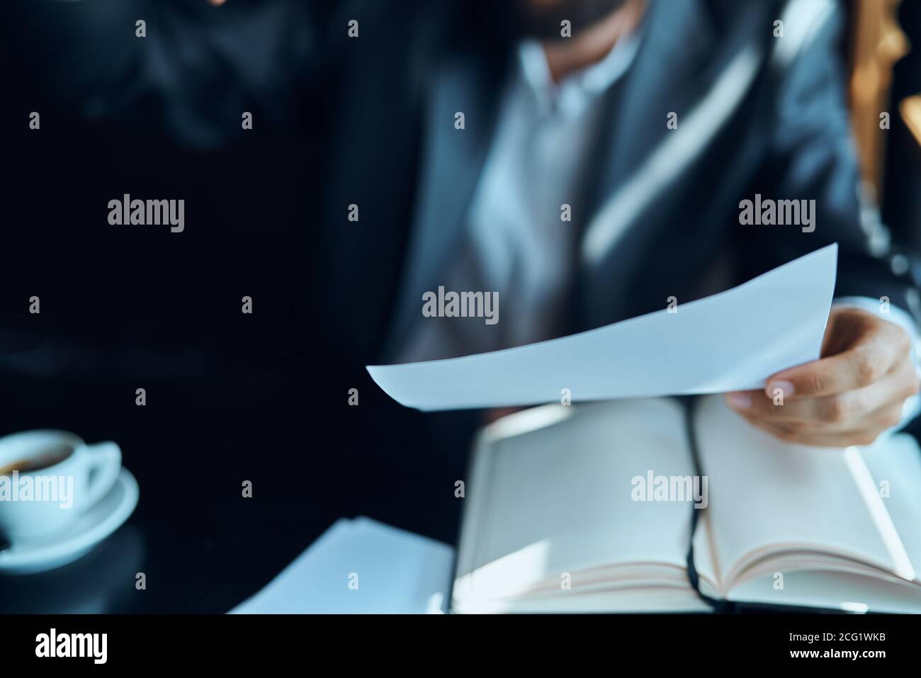 Business man in a cafe documents a cup of coffee on the table official ...
