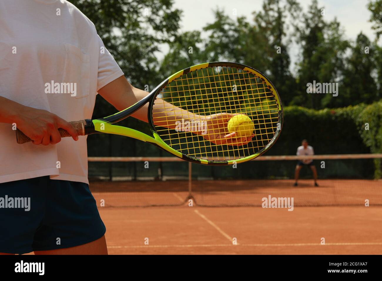 Woman hold racket and tennis ball on clay court Stock Photo - Alamy