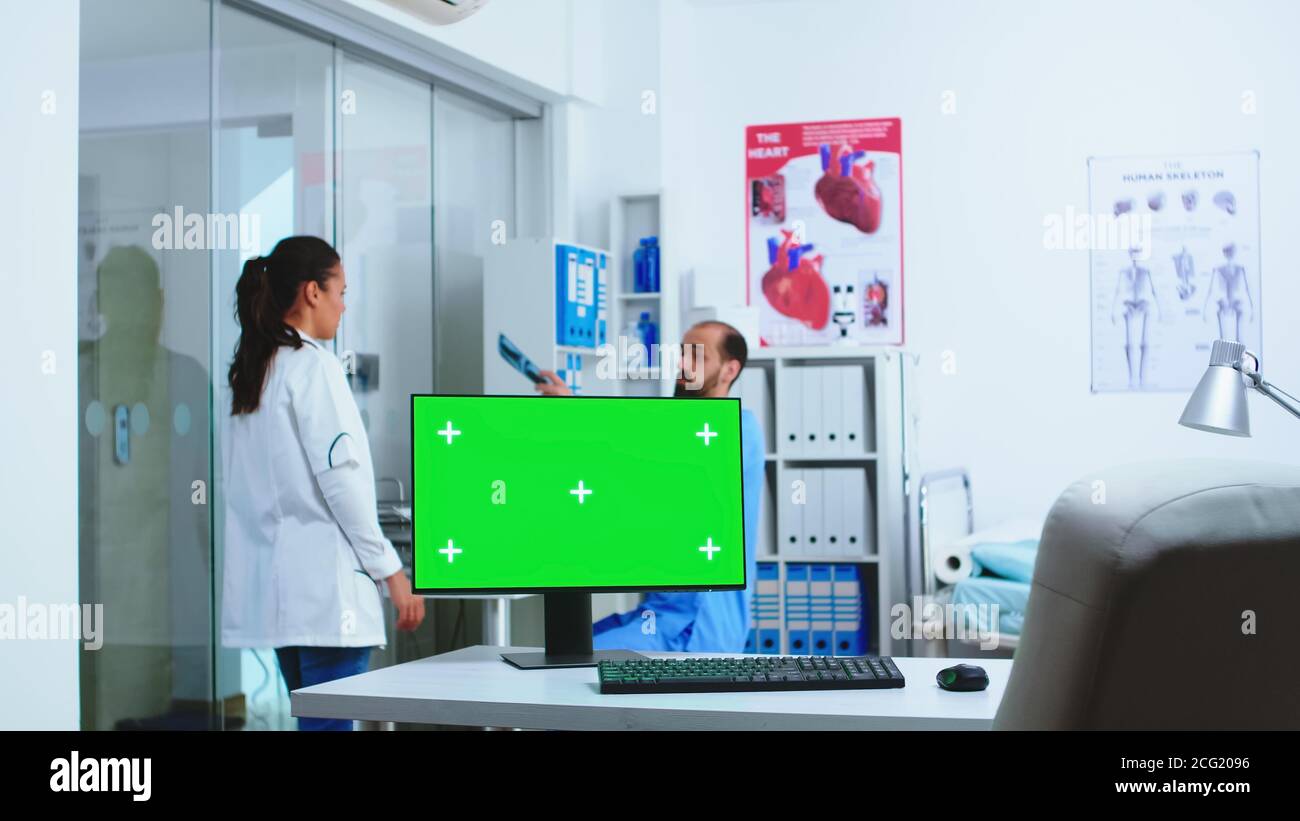 Computer with green screen in hospital cabinet and doctor checking ...