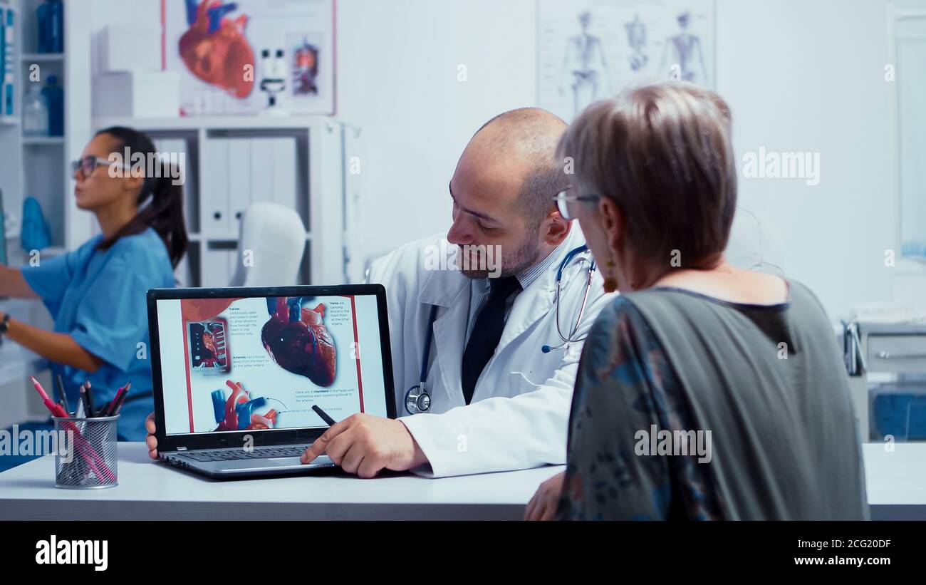 Senior retired woman patient in visit to her cardiologist doctor. Heart ...