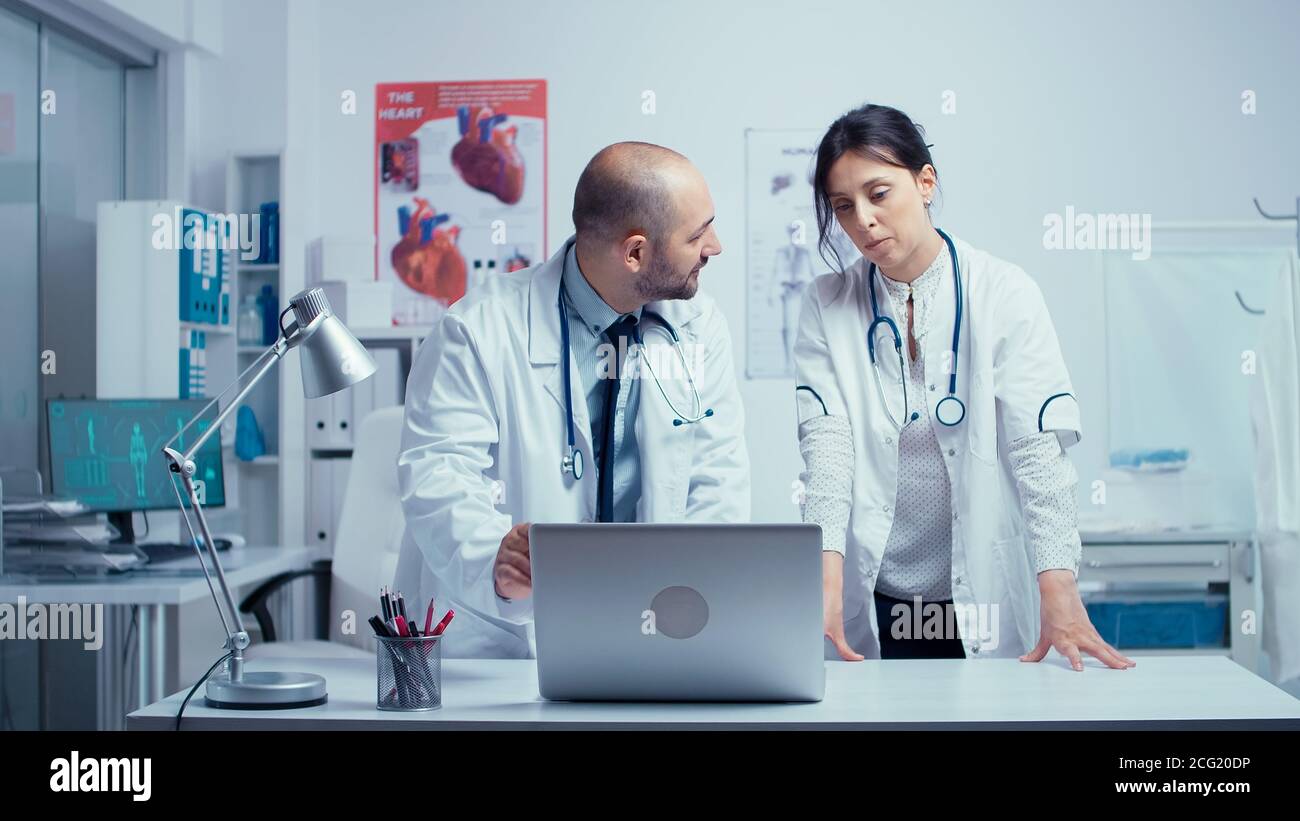 Male and female doctor practitioners consulting each other over a ...