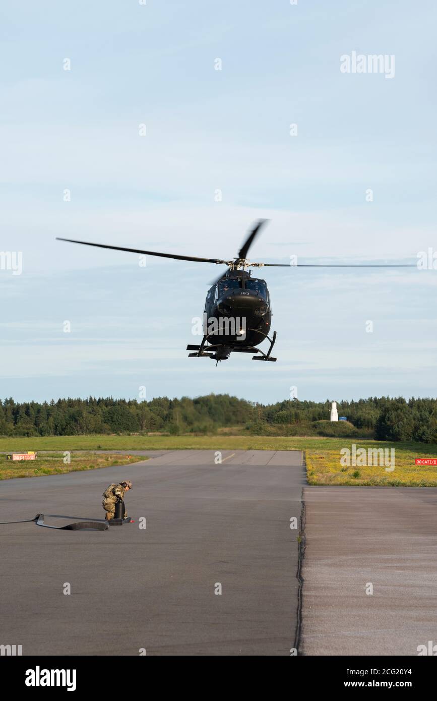 A Royal Norwegian Air Force Bell 412 helicopter hovers overhead of a ...