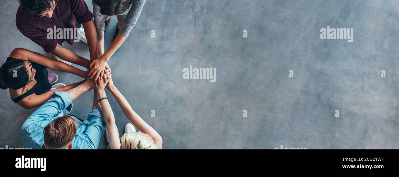 Top view shot of stack of hands. Young college students putting their ...