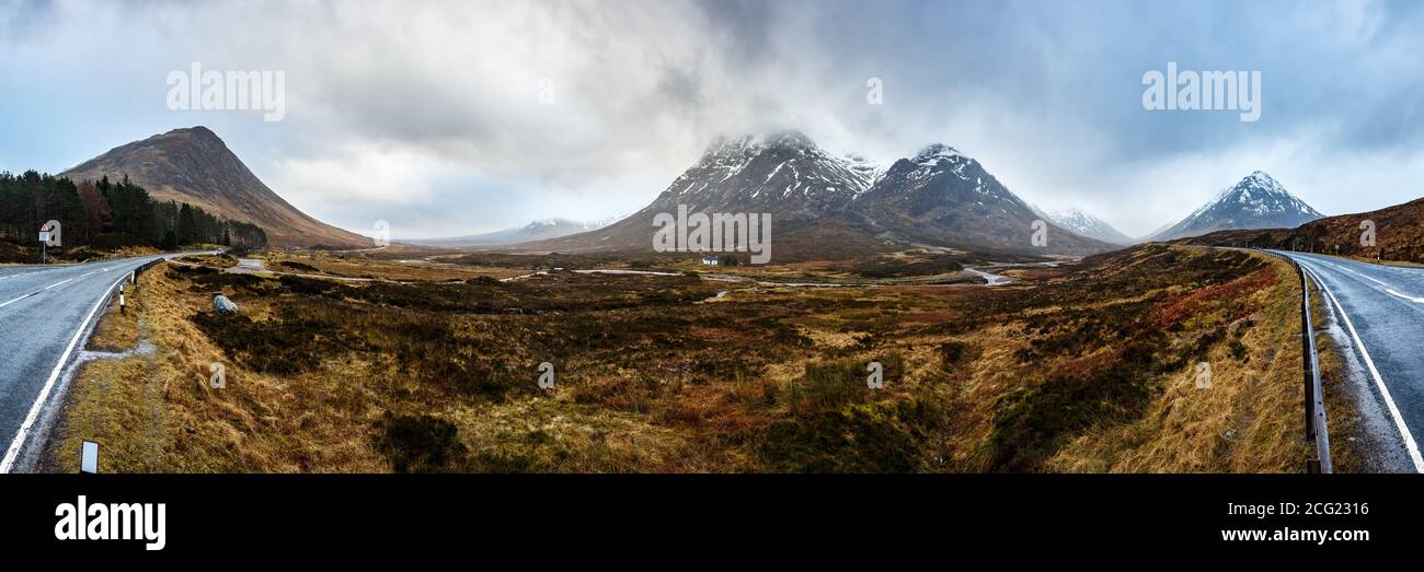 Panoramic view over the peaks in clouds with small house at Glencoe ...