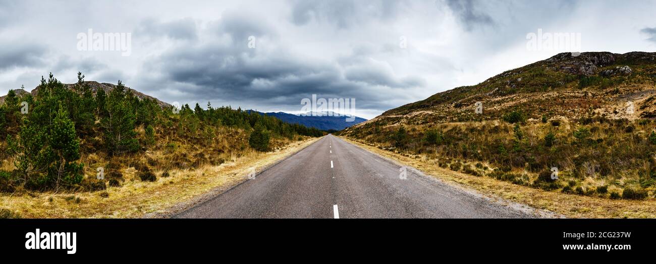 Road under the cloudy sky between two hills, somwhere in Highlands ...