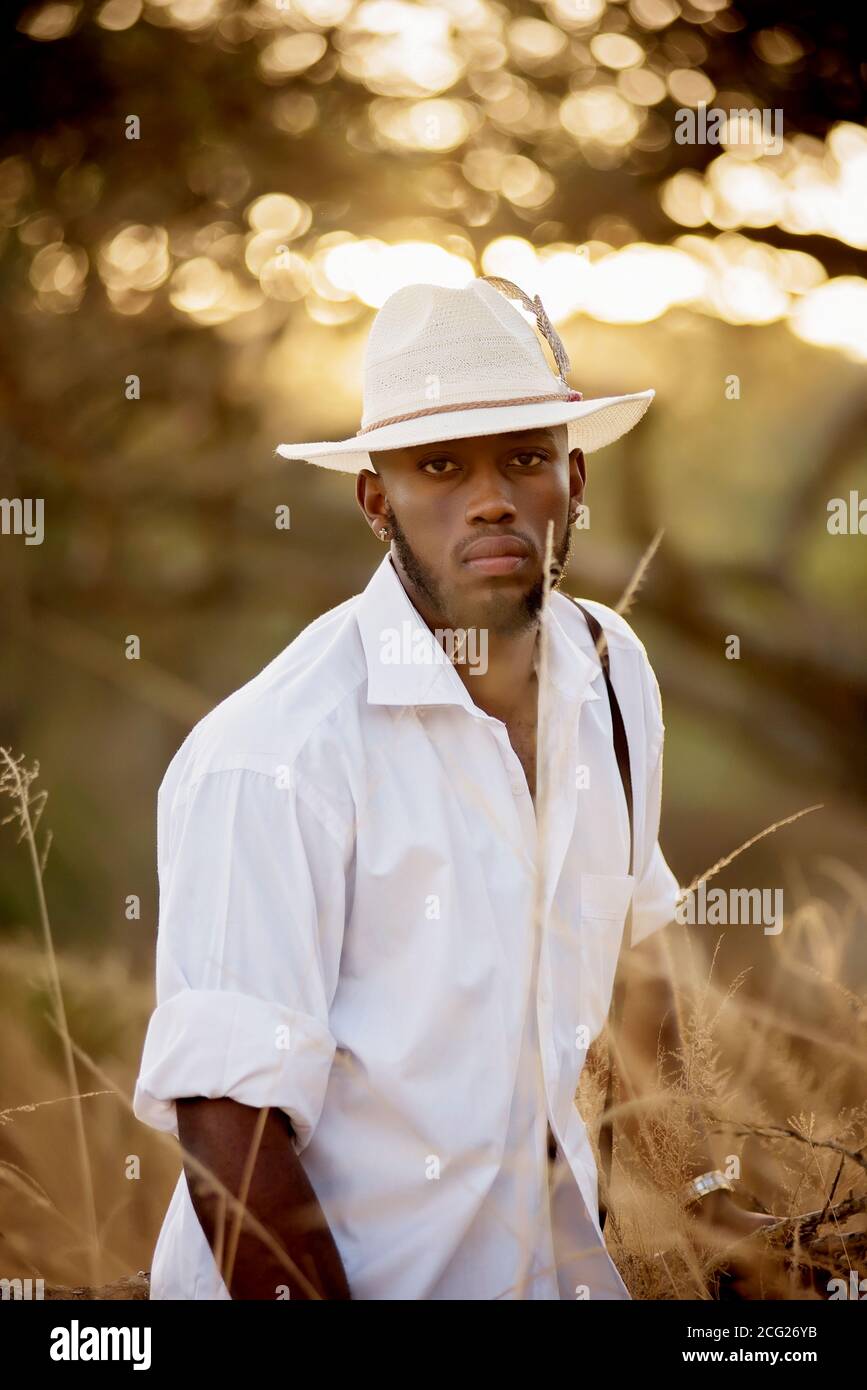african gentleman in the african bush with bush hat in the grass Stock ...