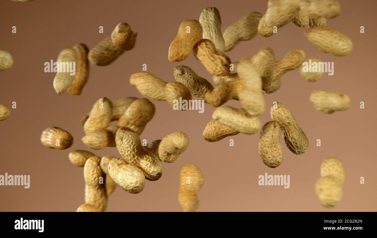 Realistic freeze motion of flying peanuts on brown background Stock ...