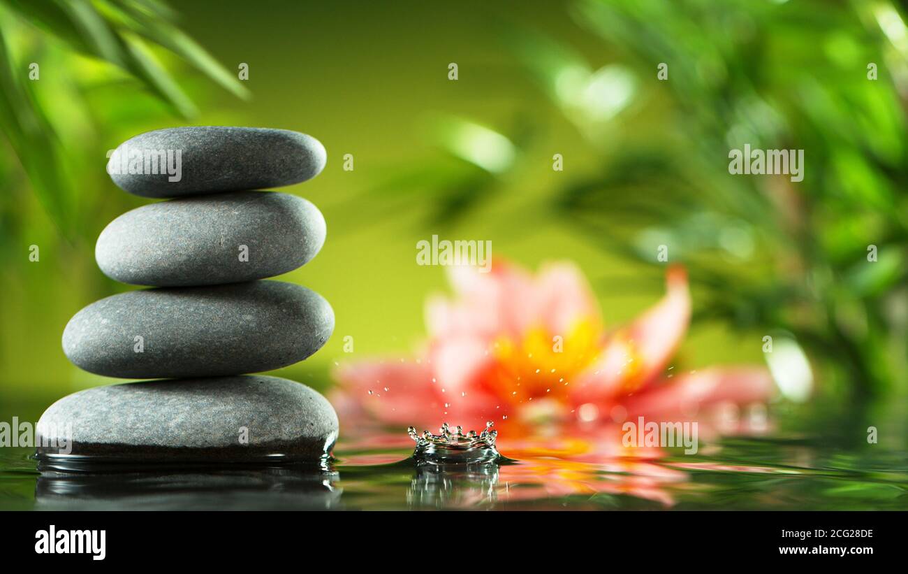 Dripping drops of water with black lava stones, spa and wellness ...