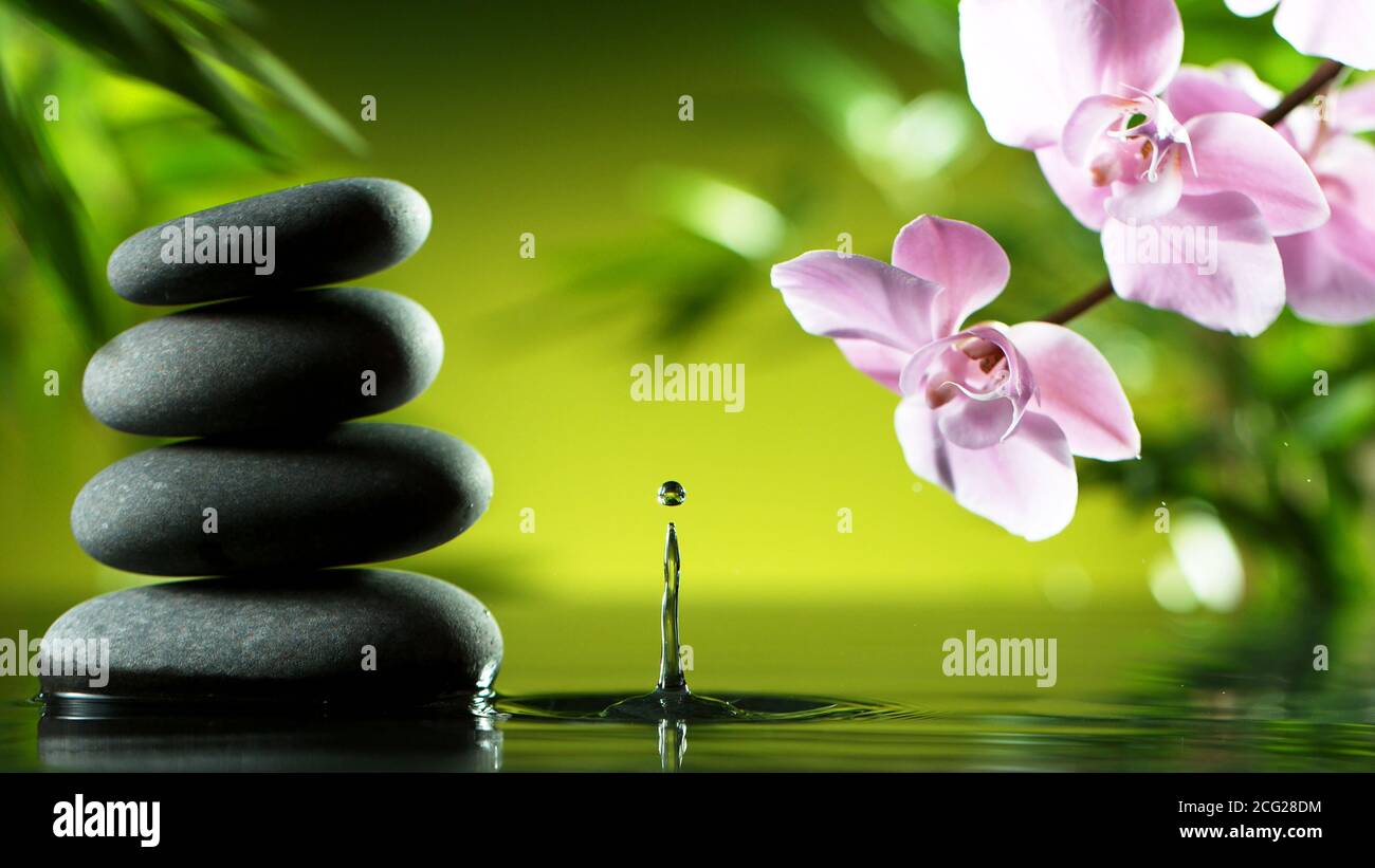 Dripping drops of water with black lava stones, spa and wellness ...