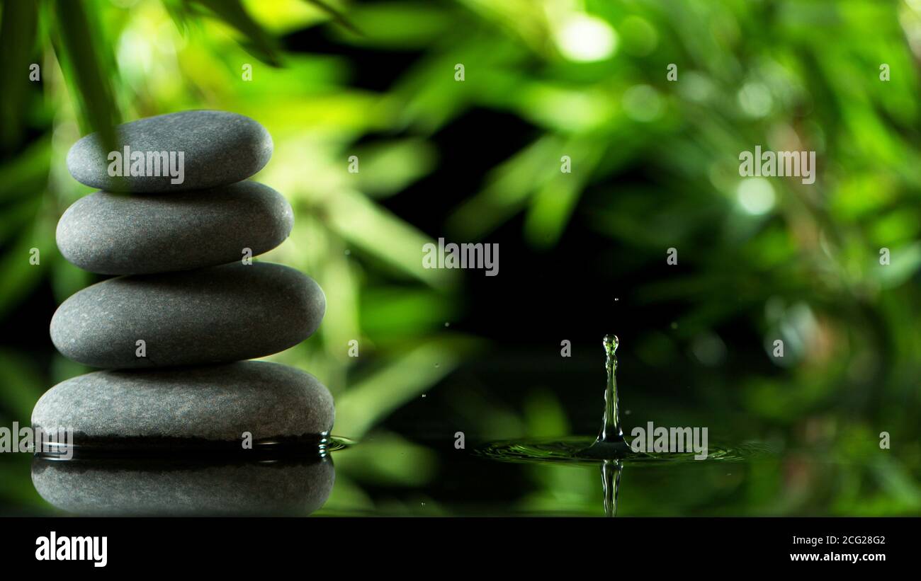 Dripping drops of water with black lava stones, spa and wellness ...