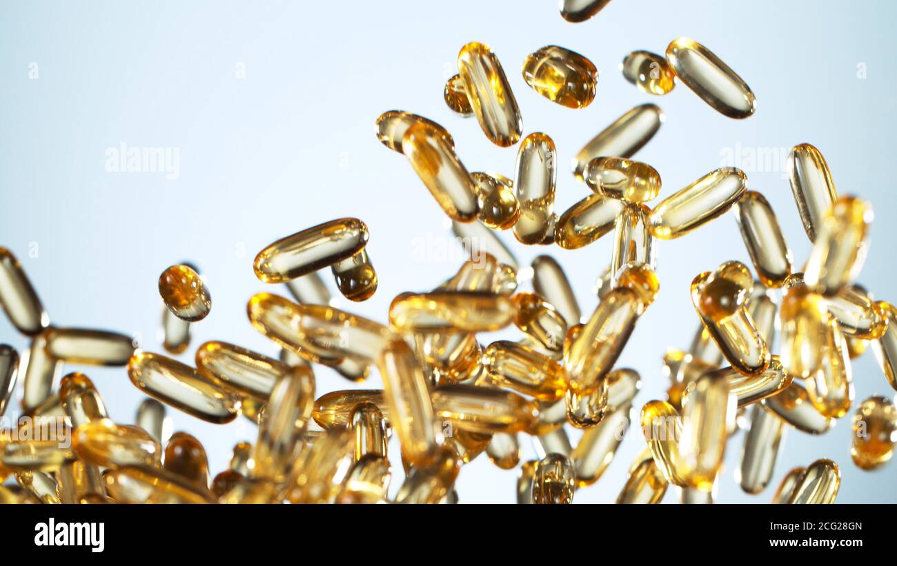 Freeze motion of flying group of fish fat pills on white background ...