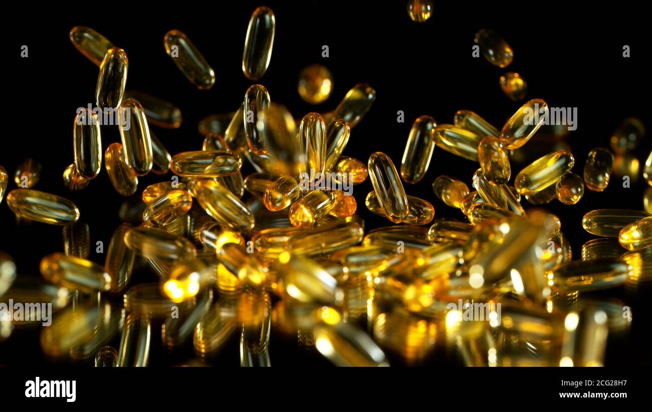 Freeze motion of flying group of fish fat pills on black background ...