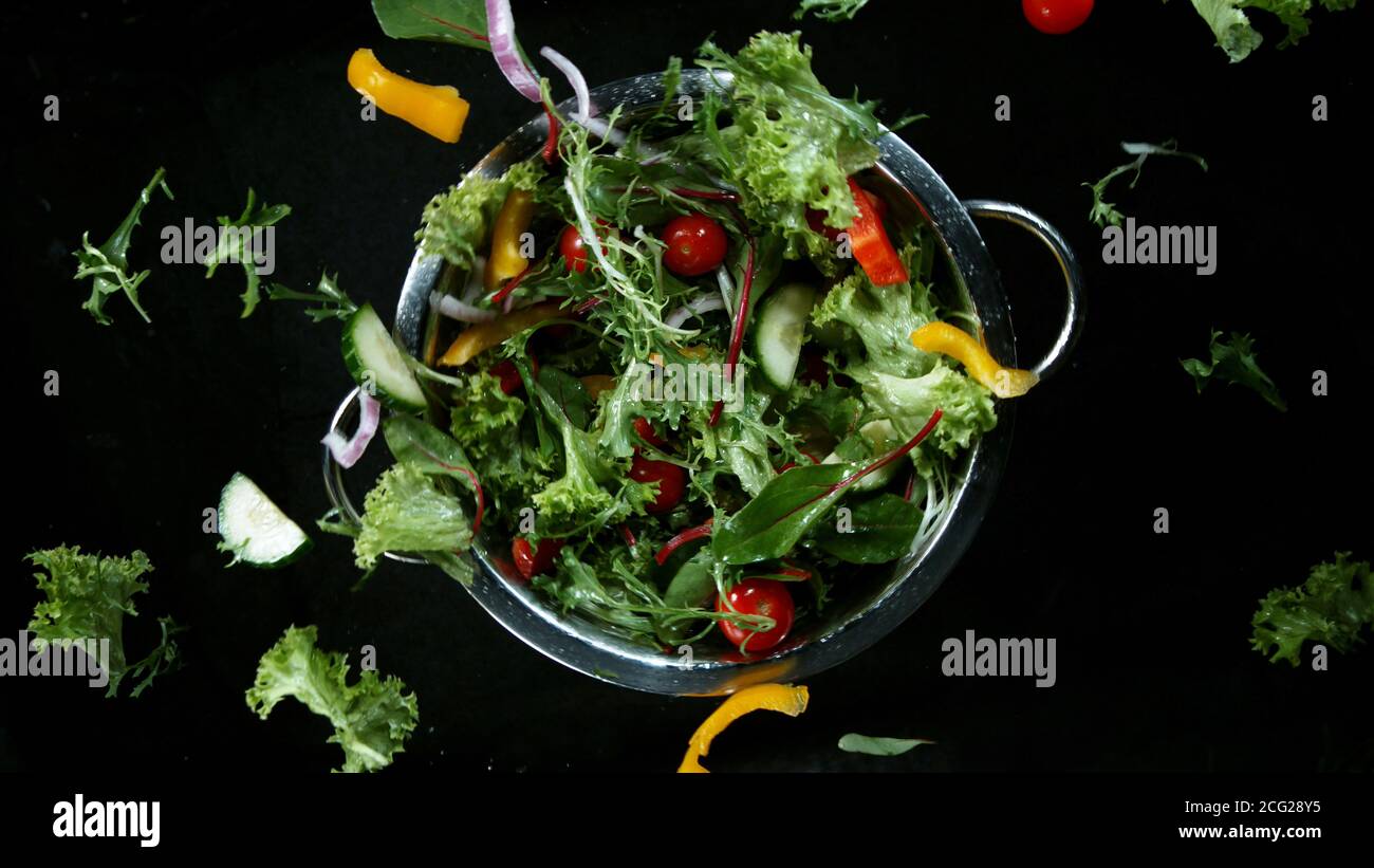 Freeze motion of rotating and flying mixed salad, isolated on black ...