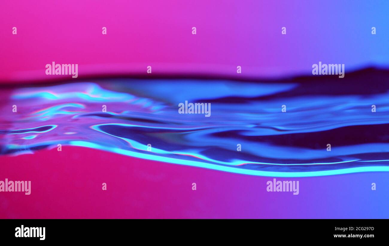 Detail of water waves highlighted by neon lights. Abstract water ...