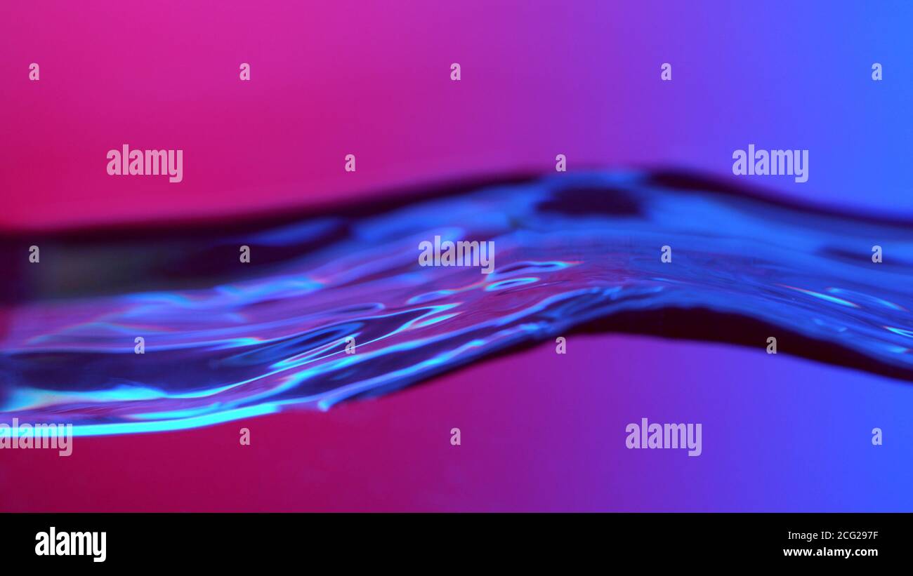 Detail of water waves highlighted by neon lights. Abstract water ...