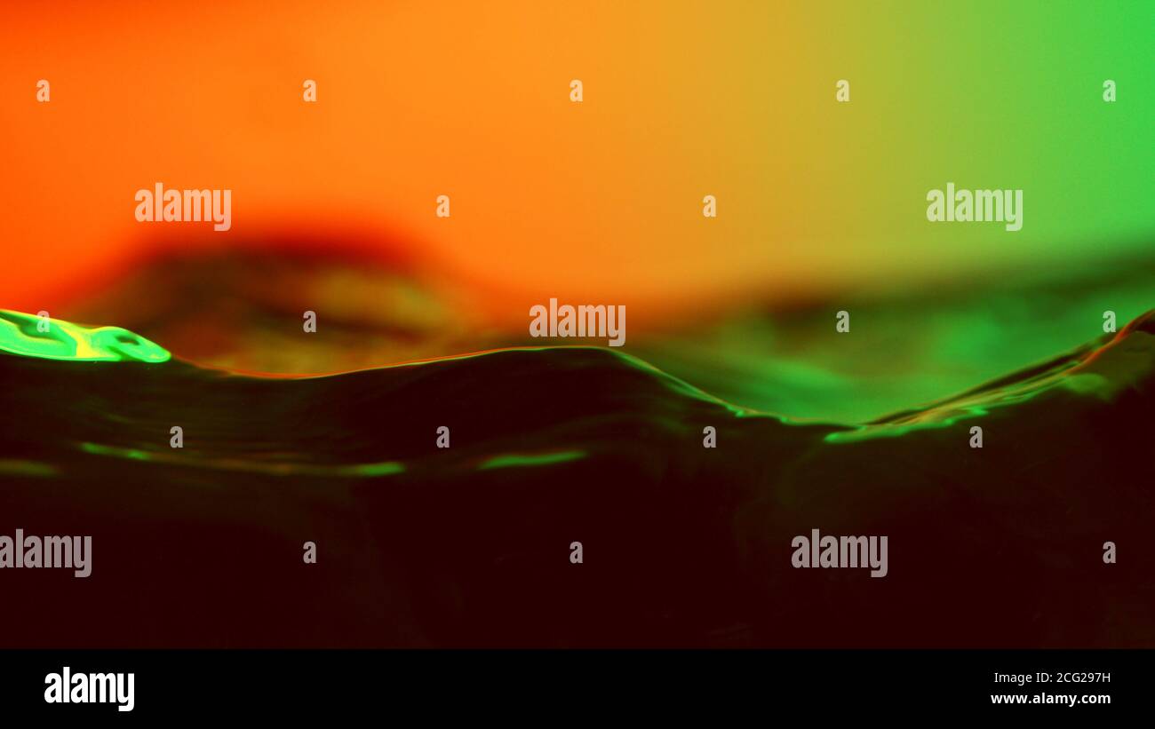 Detail of water waves highlighted by neon lights. Abstract water ...