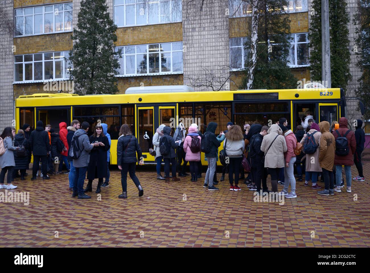 Group of young boys and girls standing in front of the school bus ready ...