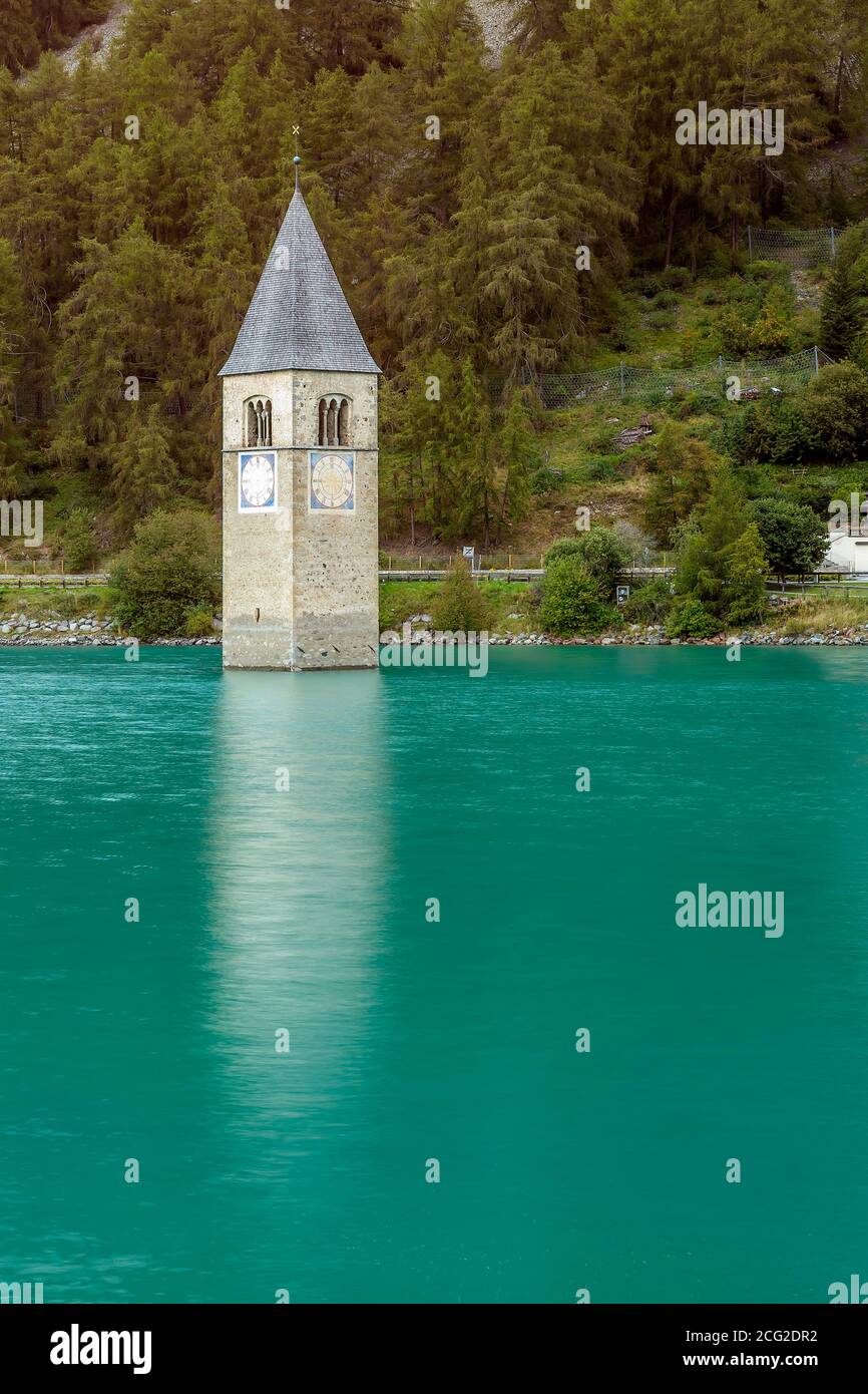 The old bell tower of Curon (Graun) emerging from the emerald waters of ...