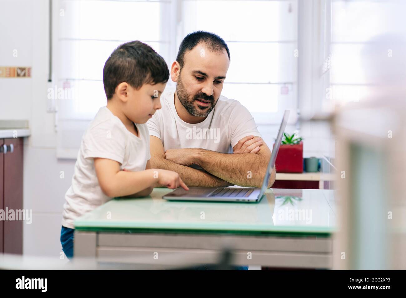 Kid using a laptop at home with parent hi-res stock photography and ...
